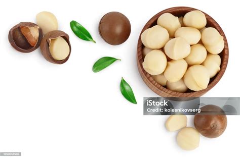 흰색 배경에 분리 된 나무 그릇에 마카다미아 너트는 클리핑 경로와 전체 깊이의 필드 텍스트에 대한 복사 공간이 있는 정상 보기