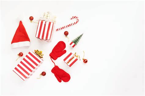크리스마스 장식의 평평한 누워 선물 상자 사탕 지팡이 나무 공 빨간 장갑 및 모자 산타 클로스 빨간색과 흰색 클래식 크리스마스 정물은 복사 공간이 있는 미니멀리스트