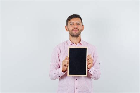 Jeune Homme Tenant Un Tableau Noir En Chemise Et à La Joyeuse Vue De