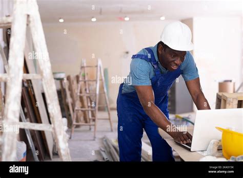 African American Engineer Checks A Home Renovation Plan On A Laptop