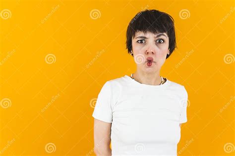 Woman With A Puzzled Expression Sucking Her Cheeks In While Looking