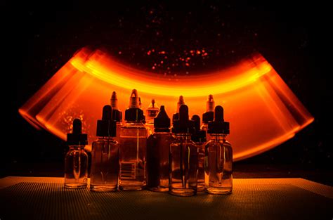 Vape 개념입니다 구름과 어두운 배경에 Vape 액체 병 연기 빛 효과입니다 Health에 대한 스톡 사진 및 기타 이미지