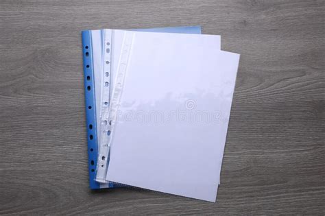 File Folder With Punched Pockets And Paper Sheets On Wooden Table Top