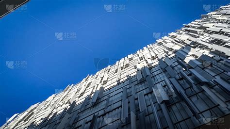 从下面直接看现代办公建筑的外部结构立面，映衬着清澈的蓝天