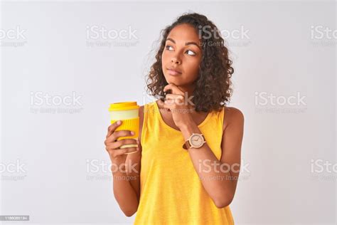 젊은 브라질 여자 마시는 떨어져 커피를 멀리 서 고립 된 흰색 배경 심각한 얼굴 질문에 대 한 생각 매우 혼란 스러운 아이디어 개념에 대한 스톡 사진 및 기타 이미지