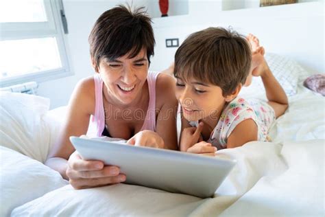 Mor I Medelåldern Med åtta års Dotter Som Använder Digitala Tabletter I