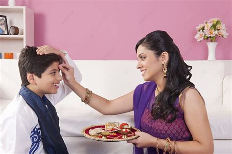 Sister Applying Tilak To Her Brother At Raksha Bandhan Photo Background