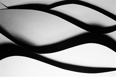 회색과 흰색의 추상적 인 기하학적 배경과 검은 그림자가있는 단단한 빛에 수평 곡선 물결 모양의 줄무늬가 솟아 오르고 명함 포스터