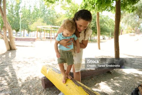 햇볕이 잘 드는 공원 환경에서 균형 빔에 유아를 안내하는 어머니 12 17 개월에 대한 스톡 사진 및 기타 이미지 12 17 개월 2명 40 44세 Istock