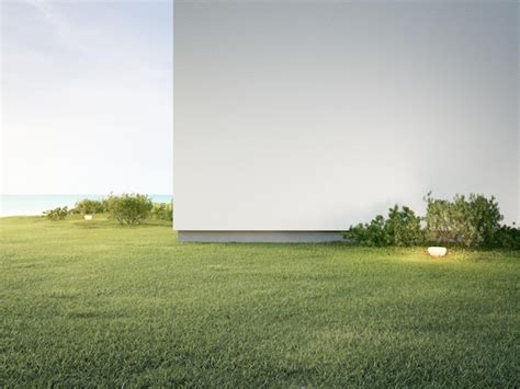 빈 잔디 바닥 근처에 흰색 콘크리트 벽이 있는 집 현대 가정에서 녹색 잔디의 3d 렌더링입니다 프리미엄 사진
