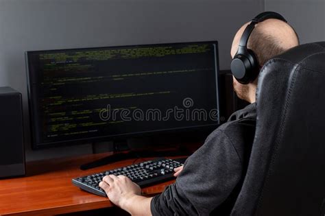 Programming A Man Working On A Computer In It At Home Sitting At A Table Writes Codes Stock