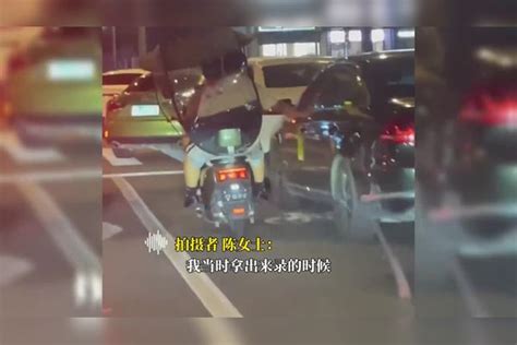 俩男子晚上十点多骑电车，给停在路边的汽车贴小广告