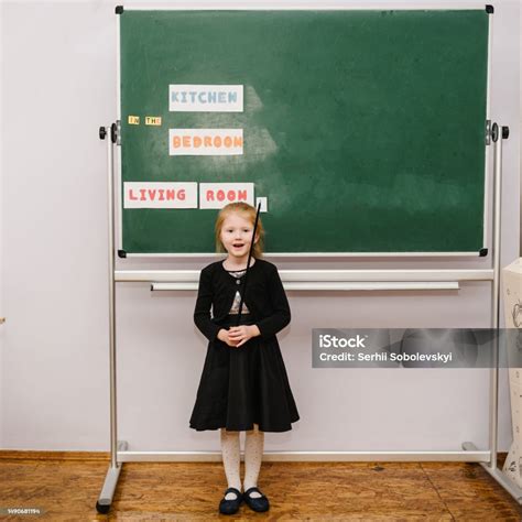 학생들은 학교에서 공부하고 칠판 근처에 서서 대답합니다 초등학교 교실에서 소리와 글자를 읽는 귀여운 여학생 초등학교에서 시험을 치르는 학생 영어 수업 6 7 살에 대한 스톡