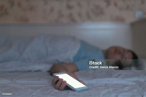 젊은 남자는 피로의 결과로 손에 스마트 폰으로 잠들었다 누적 된 피로 휴대 전화에 충분한 수면과 의존성 25 29세에 대한 스톡 사진 및 기타 이미지 Istock