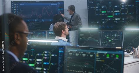 Technical Support Specialists Sit At Computers With Displayed Blockchain Network Map And Server