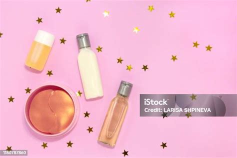 여성을위한 장식 뷰티 액세서리 세트 하이드로 겔 화장품 아이 패치 항아리와 크림과 젤 병 황금 별 핑크 배경에 피부 관리를위한 플랫 레이 상단 보기 0명에 대한 스톡 사진