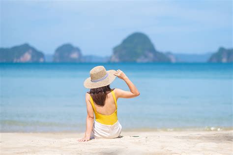 노란 수영복과 모자를 쓴 여성 관광객 섬의 파라다이스 해변에서 일광욕을하는 행복한 여행자 목적지 방랑욕 아시아 여행 열대 여름 휴가 및 휴가 개념 30 34세에 대한 스톡