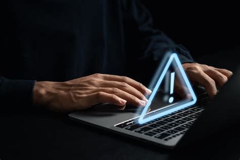 premium photo typing with warning alert on laptop