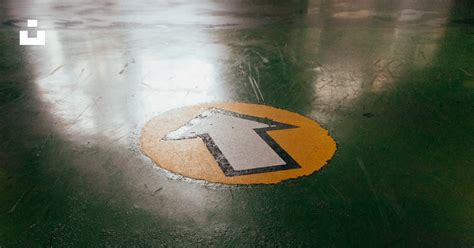 녹색 바닥 위에 앉아 있는 노란색과 검은색 화살표 기호 사진 Unsplash의 무료 길 찾기 이미지