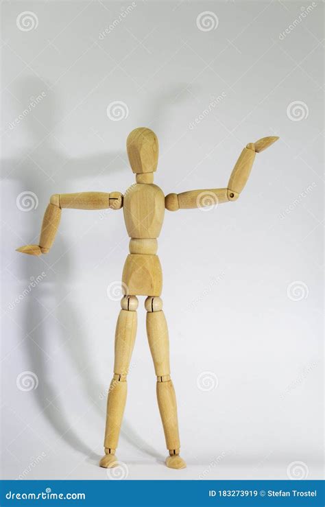 Wooden Doll Doing Stretching Exercises In Front Of A White Background