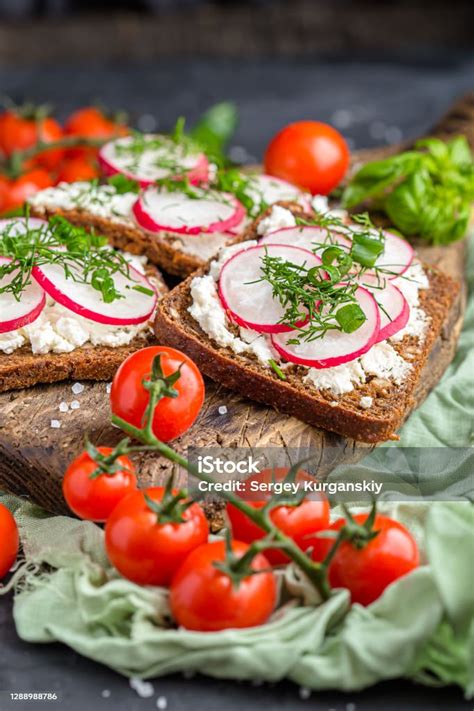 크래커에 담긴 코티지 치즈 얇게 썬 검은 빵 무를 딜 상단 및 사이드 샷으로 웨지로 썰어 나무 도마위에 흰색 으로 고립된 배경