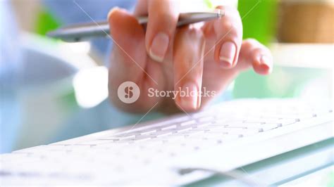 woman office worker typing on the keyboard and makes notes on paper