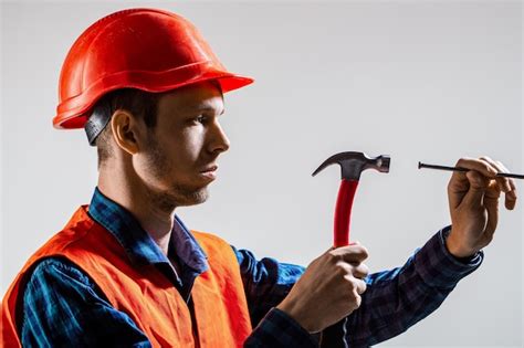 Premium Photo Man Builder Hammer Hammering Builder In Helmet Hammer