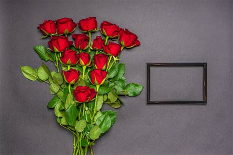 검은 배경에 신선한 빨간 장미 꽃과 빈 포토 프레임의 꽃다발 꽃 구성 이벤트에 대한 애도 카드 조롱 애도 애도 기념 개념 플랫