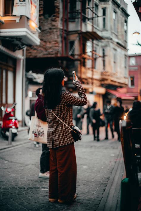 Selective Focus Photography Of Woman Taking Photo While Standing On