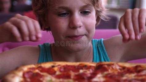 A Teenage Girl Looks At Pizza With Pleasure And Chooses A Slice