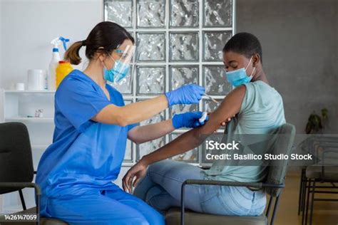 여성 의료 전문가가 흑인 여성에게 예방 접종을합니다 간호사에 대한 스톡 사진 및 기타 이미지 간호사 독감 예방접종 성인